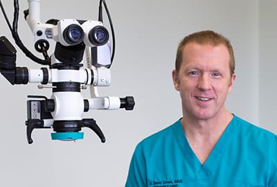 Dr. Cross Next to Microscope - J. David Cross, DDS